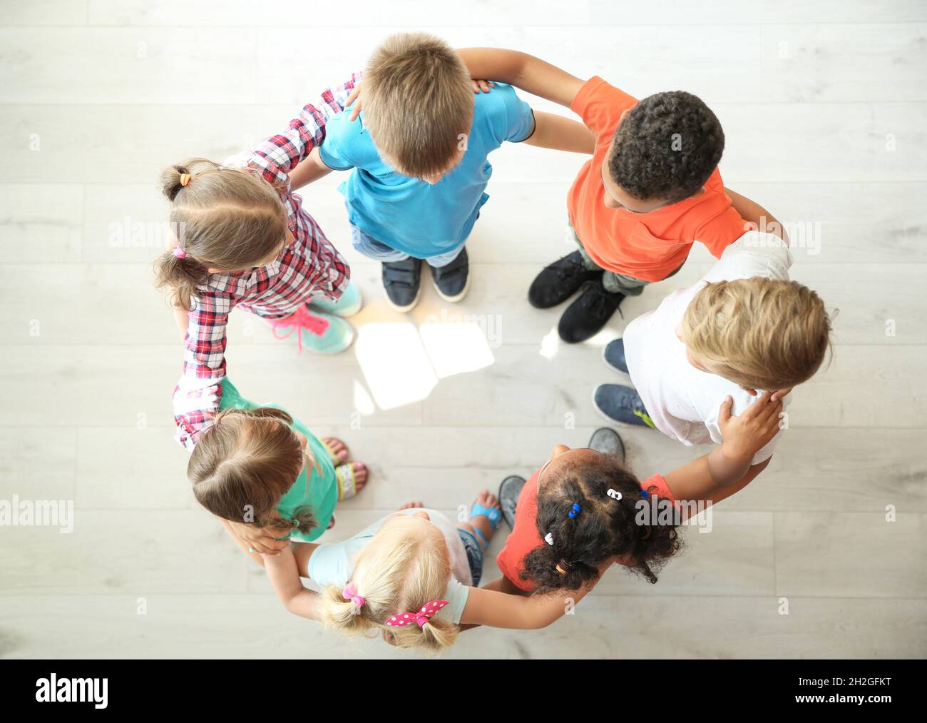 Little children making circle with hands around each other indoors, top ...