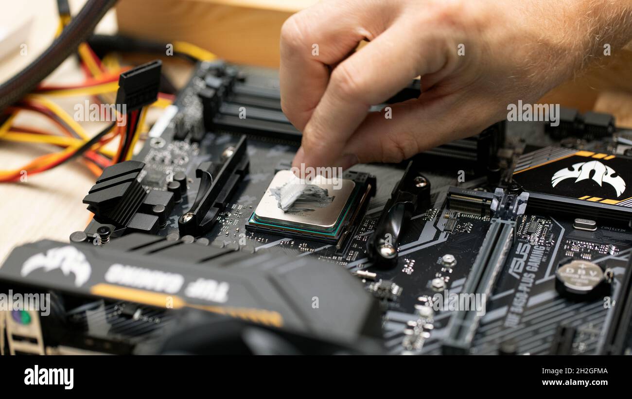 man apply thermal paste for installing microprocessor on Tuf Gaming b450 plus motherboard ...