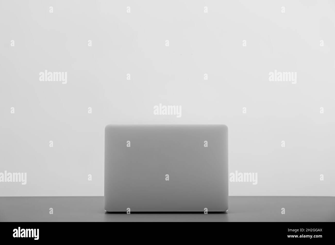 Modern laptop on table against light background Stock Photo - Alamy