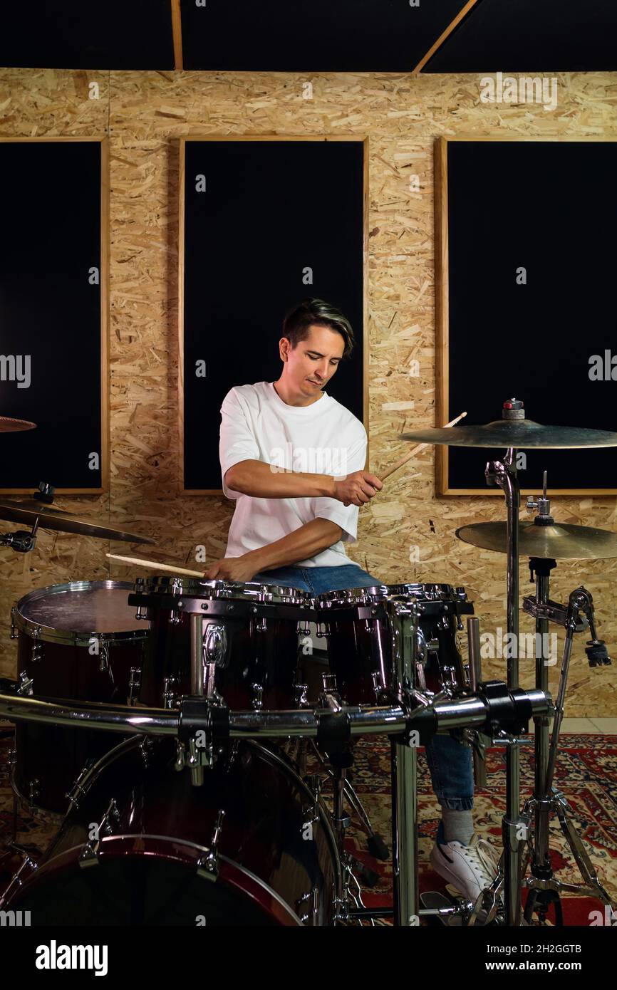 Full length young man playing drum set. Active artist beating rhythm in ...