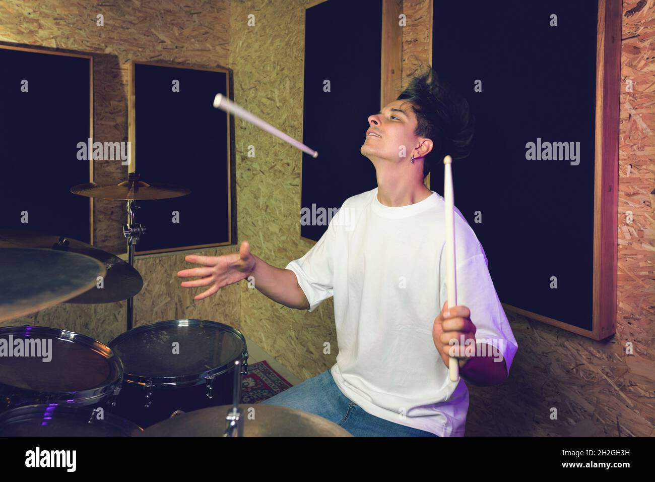 Musician artist beating rhythm is rehearsing behind drum kit in ...