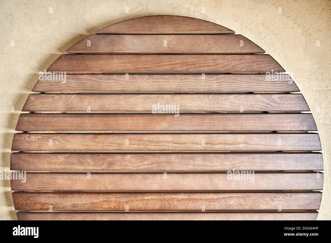 Round table top made of wooden slats for outdoor table lying on dusty ...