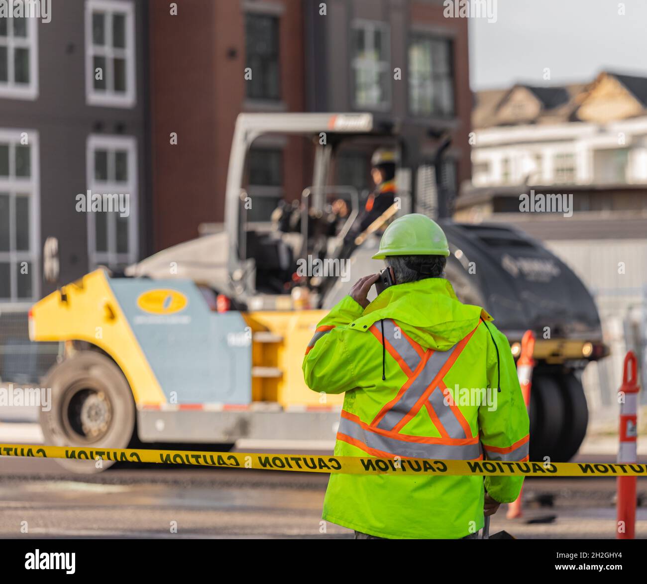 Roadworks signal with worker standing. Traffic control manager watching ...