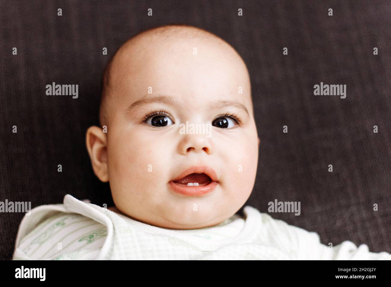 Sweet little baby boy with chubby cheeks and big eyes. Portrait of ...