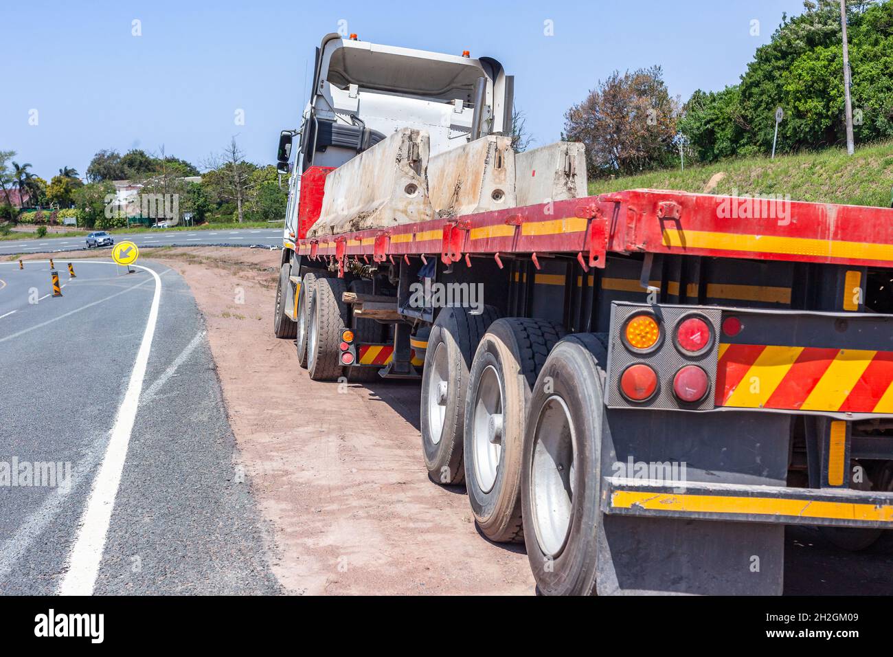 Trucking concrete road barriers equipment off the finished highway road ...