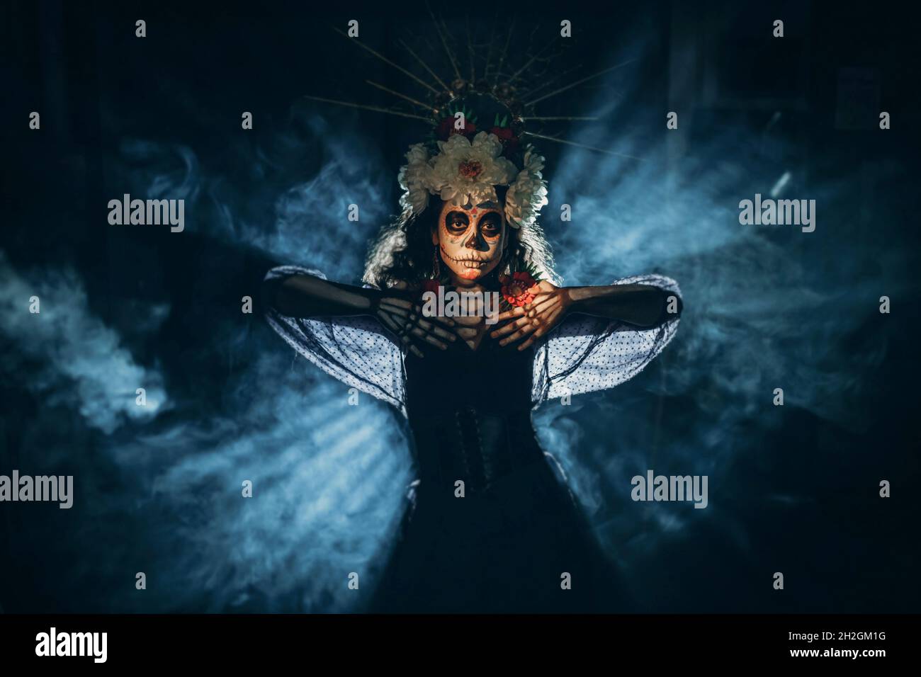 Woman with mexican sugar skull halloween makeup in dark with backlight ...