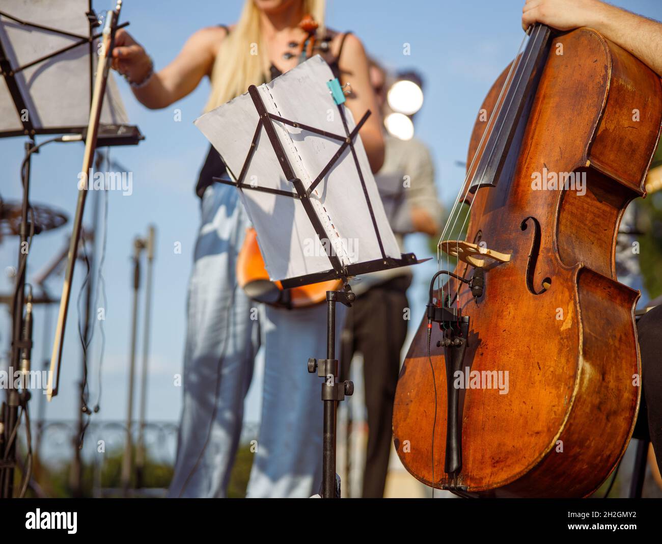 Musician with violoncello sitting near music note stand Stock Photo - Alamy