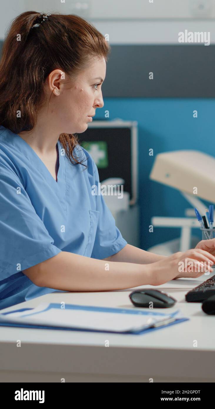 Nurse typing on computer keyboard for consultation and appointment ...