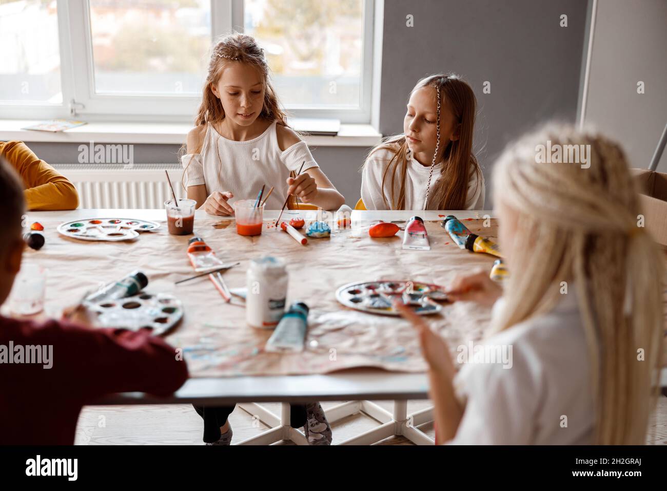 Classmates painting on paper with colorful paints Stock Photo - Alamy
