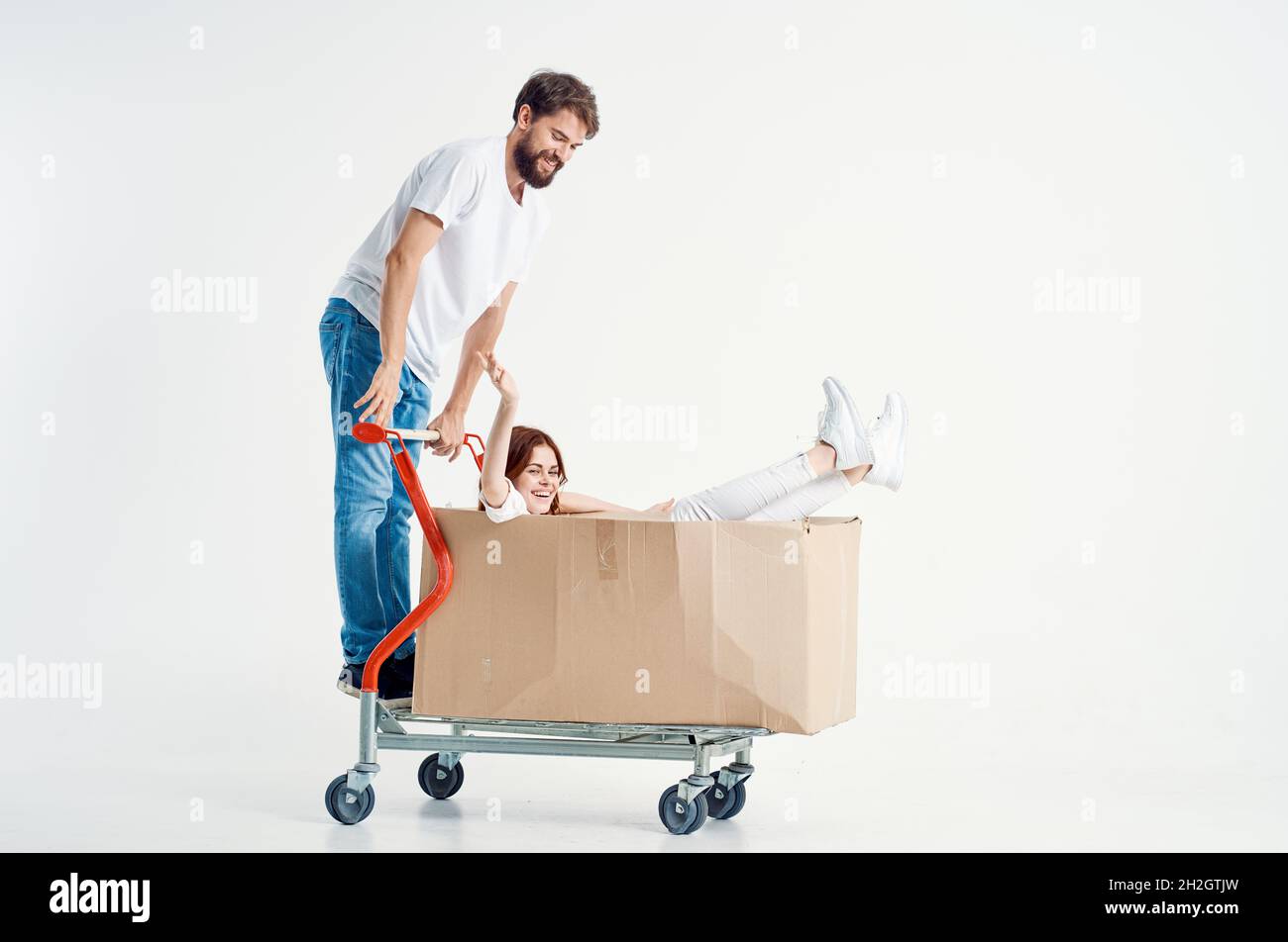 a young couple ride a cart entertainment light background Stock Photo ...