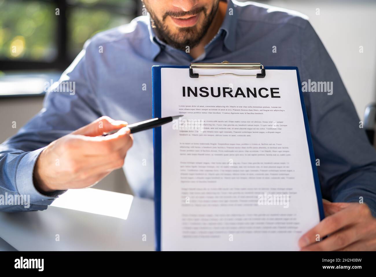 Male Agent Showing Company Insurance Policy Document Stock Photo - Alamy