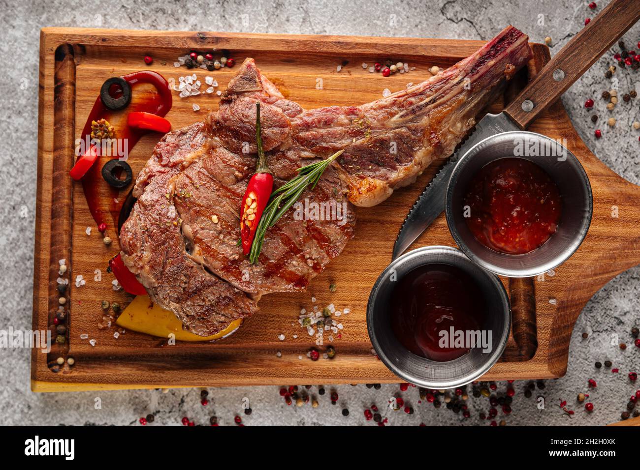 Grilled beef tomohawk steak with sauces Stock Photo - Alamy