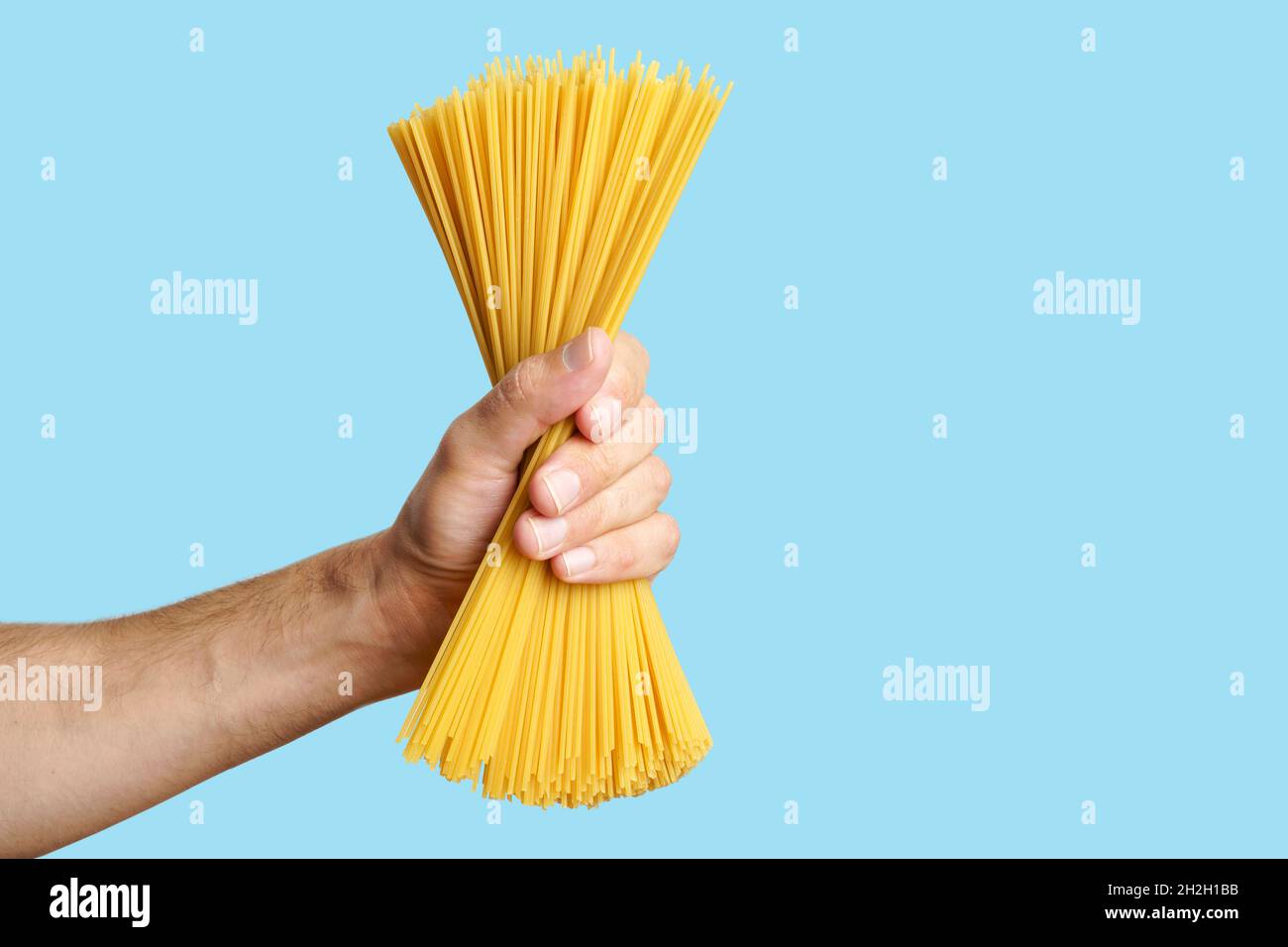 Spaghetti pasta in hand on a blank background. Raw Italian spaghetti ...