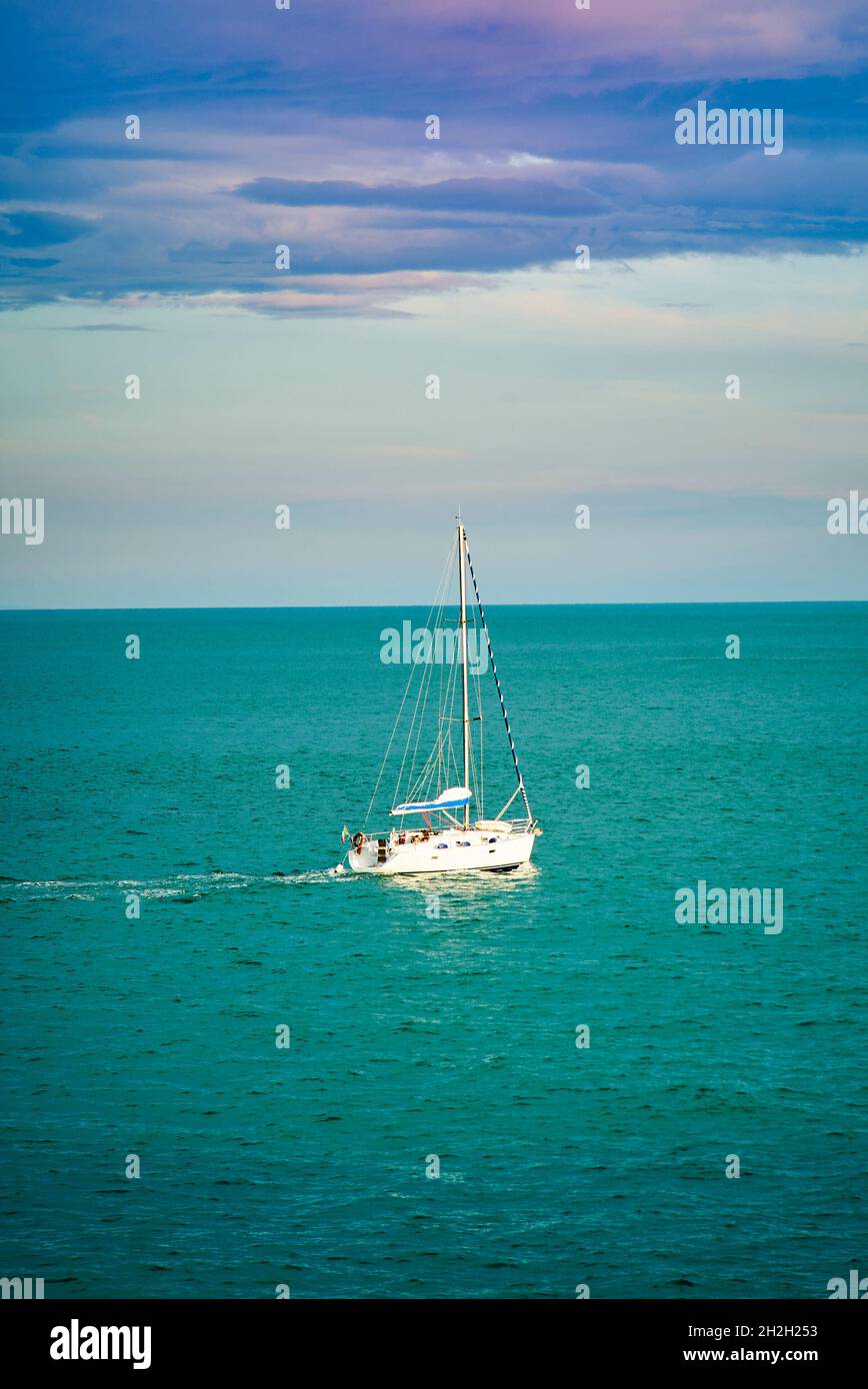 A sailboat on the coast drives with engine Stock Photo - Alamy