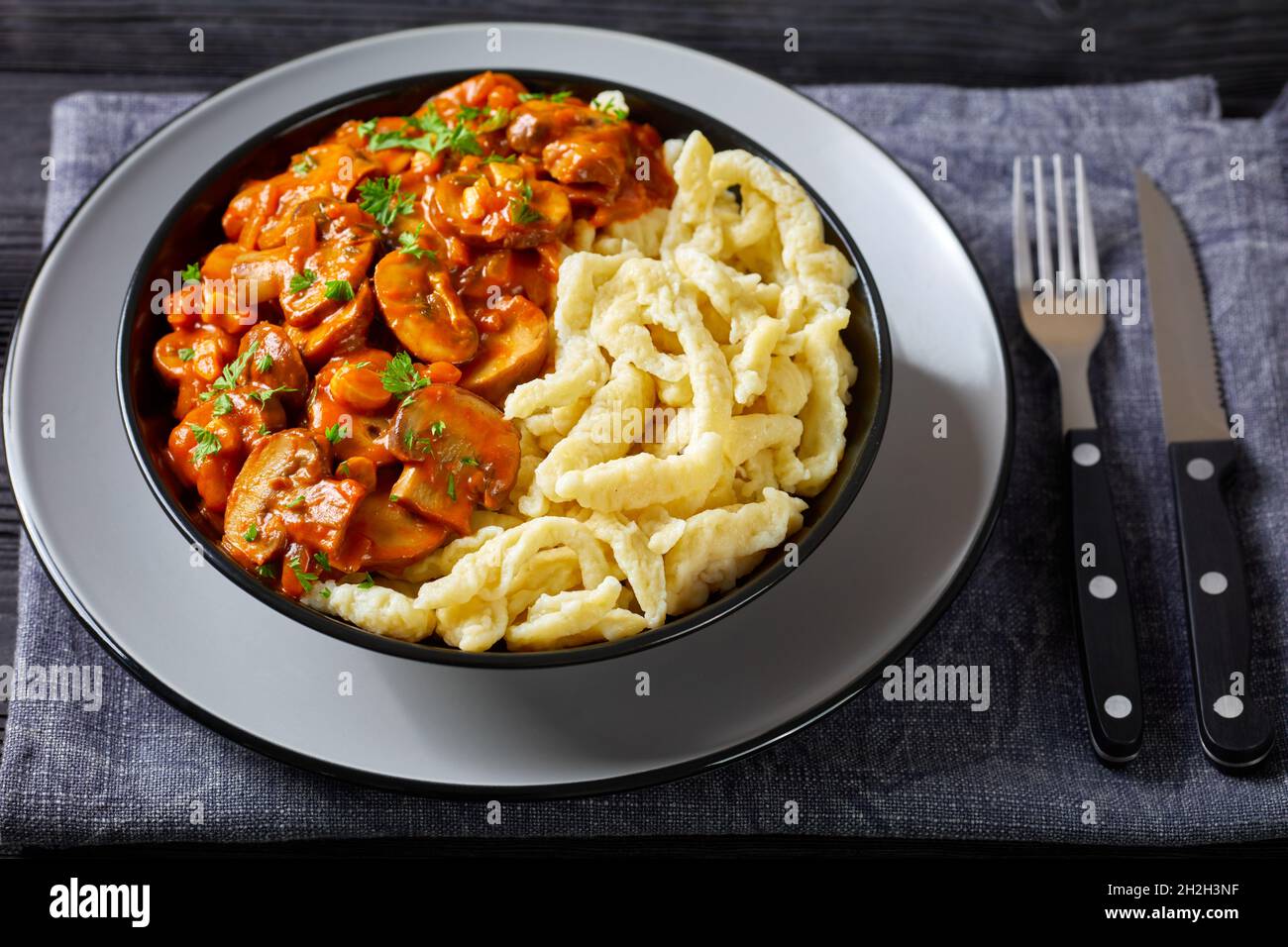 spaetzle with mushroom gravy in a black bowl, jagerspatzle ...