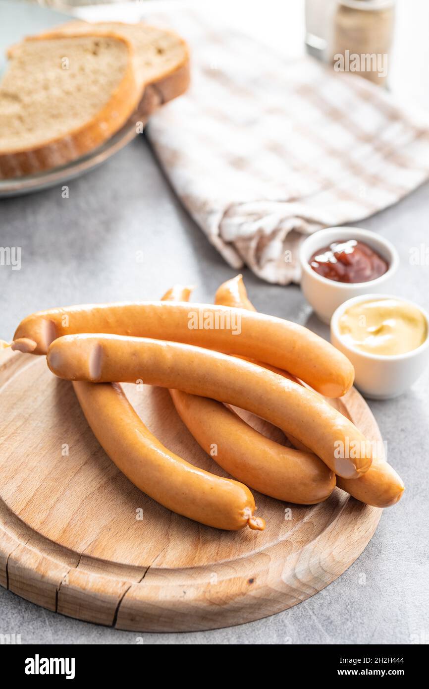 Smoked frankfurter sausages on cutting board on kitchen table Stock ...