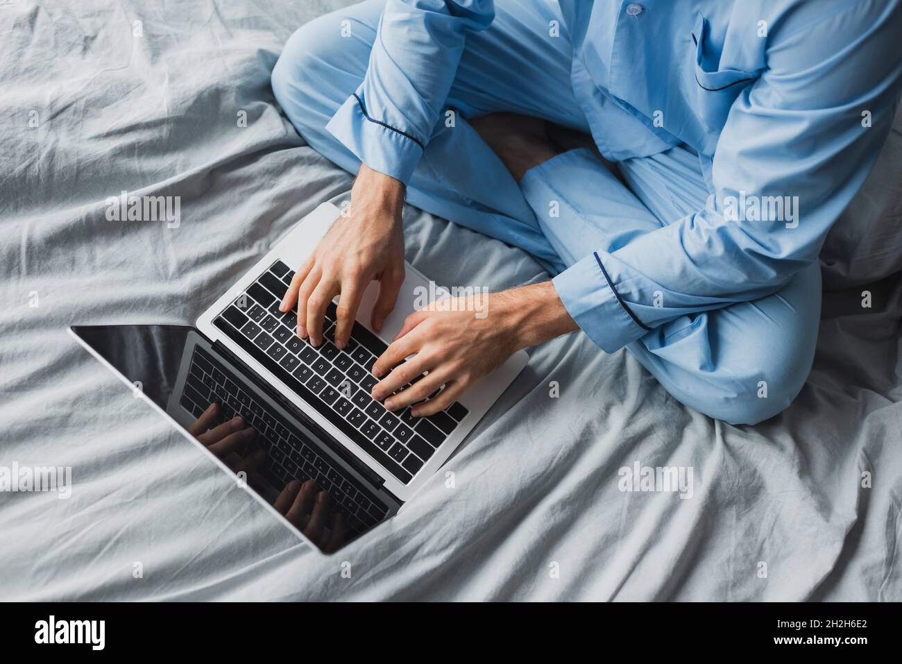 Top view of young freelancer in pajama using laptop with blank screen ...