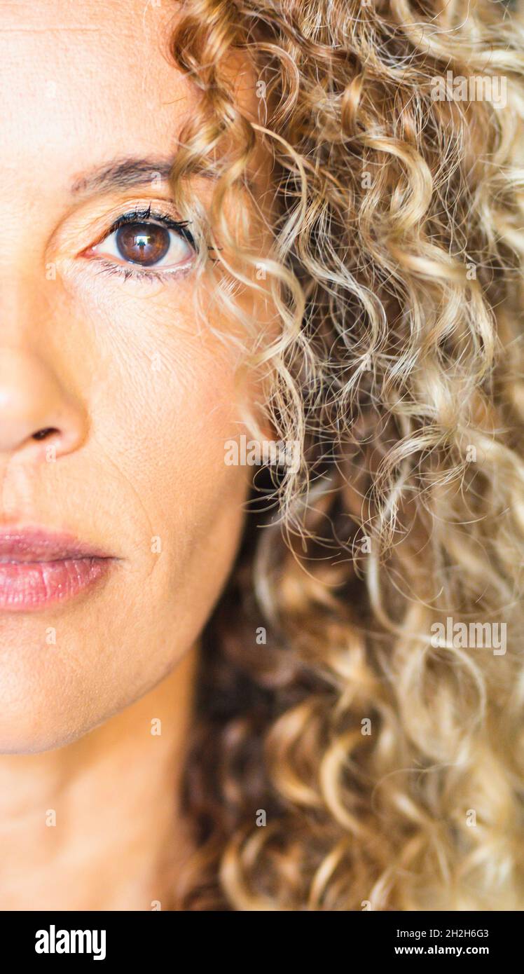 Portrait of beautiful caucasian woman with curly hair looking at camera ...