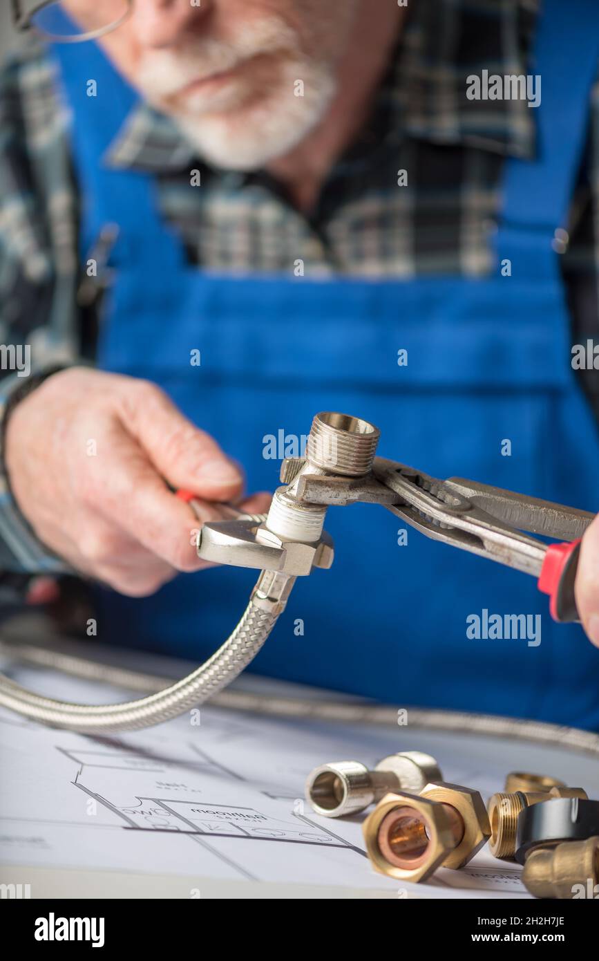 Plumber screwing a plumbing fitting on a pipe Stock Photo - Alamy