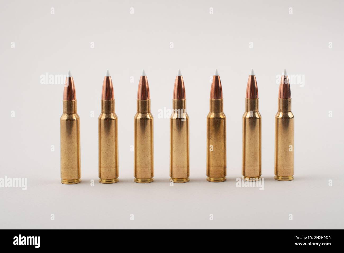 Rifle bullets in a row isolated on grey background Stock Photo - Alamy