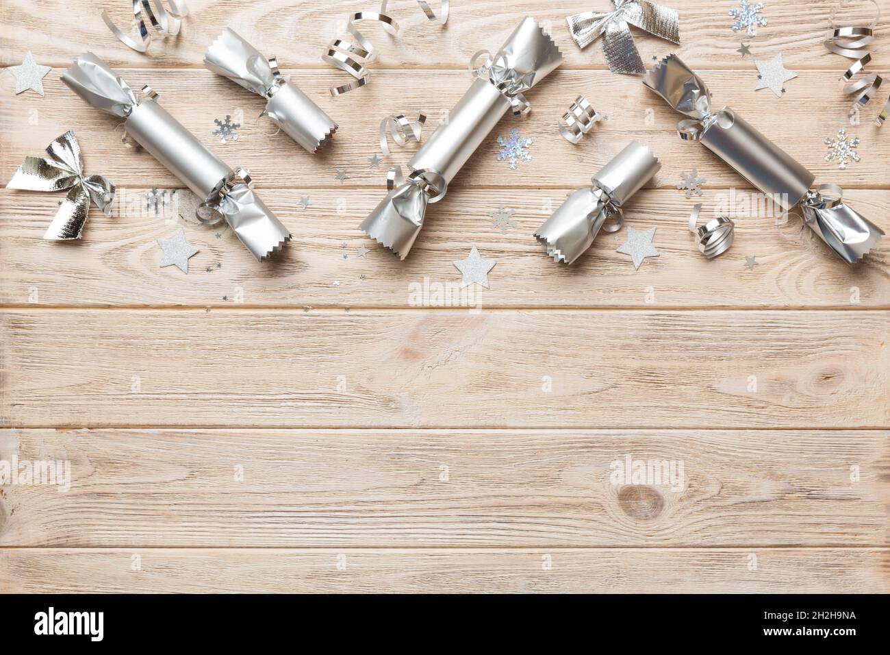 Christmas crackers with shiny confetti on color background, top view ...