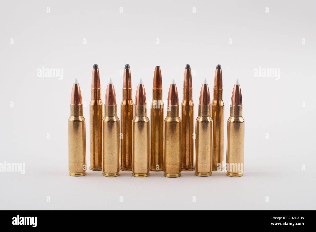 Rifle bullets in a row isolated on grey background Stock Photo - Alamy