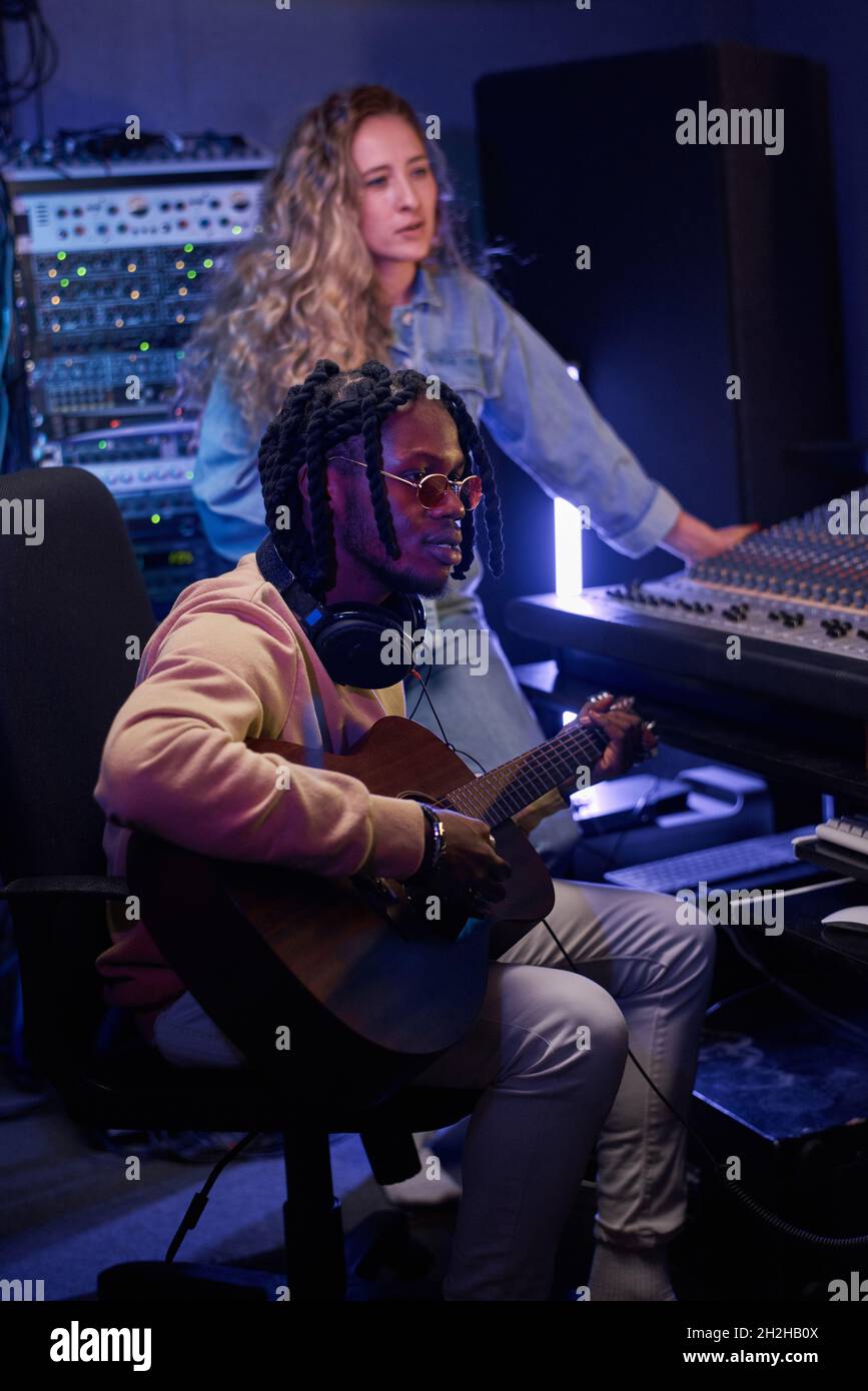 Young musician playing guitar and writing song together with his ...