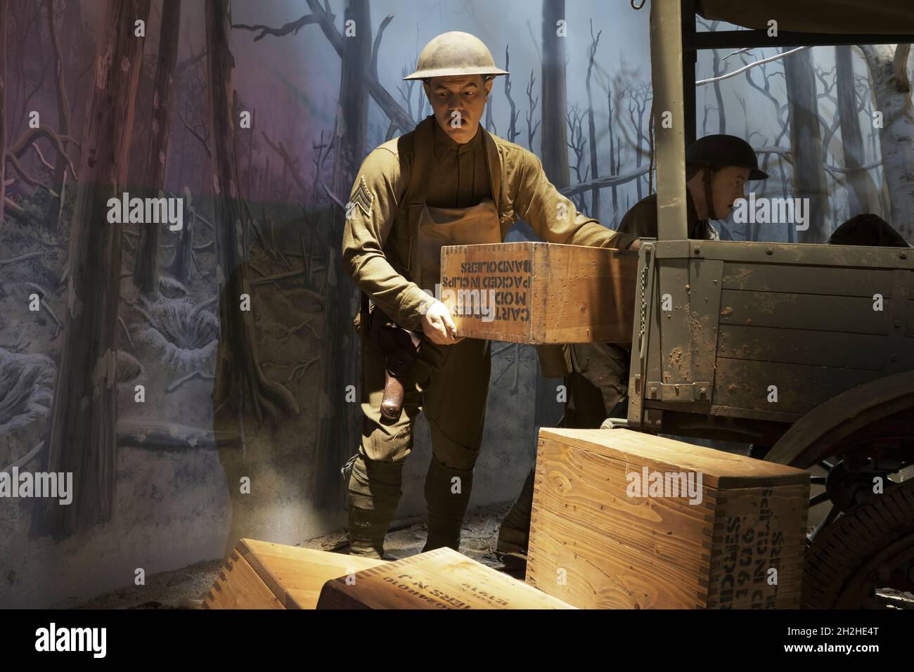 A soldier unloading wood boxes, crates from a truck during WWI. At the ...