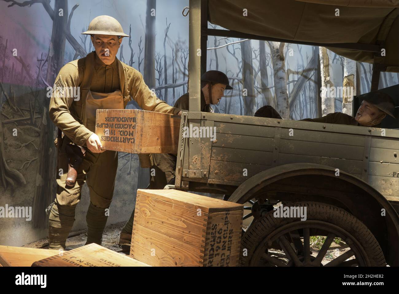 A soldier unloading wood boxes, crates from a truck during WWI. At the ...
