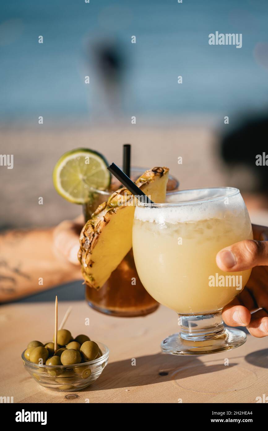 Vertical shot of two people clinking cocktail glasses Stock Photo - Alamy