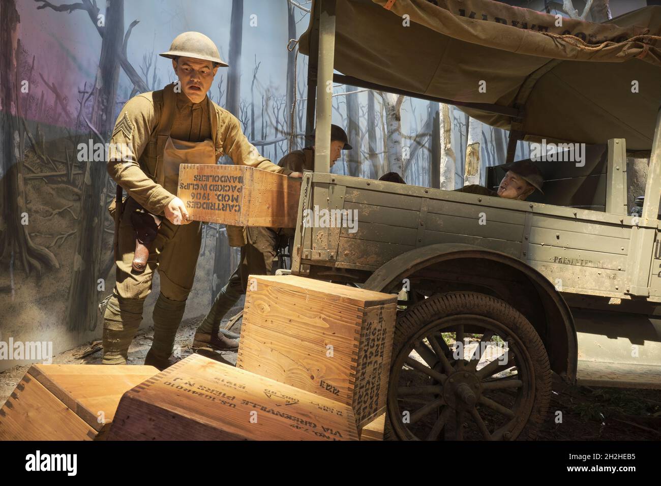 A soldier unloading wood boxes, crates from a truck during WWI. At the ...