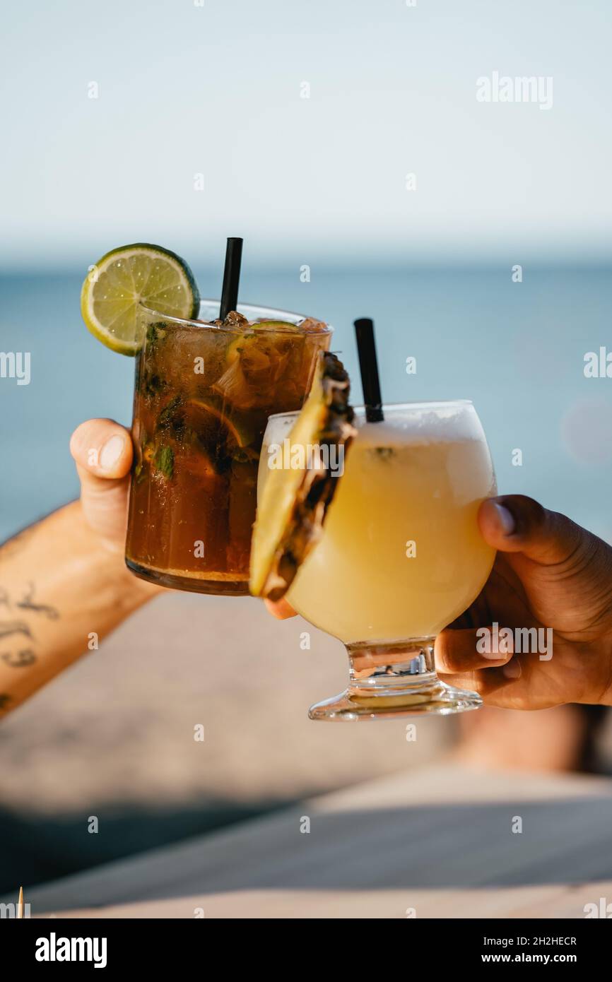 Two people clinking cocktail glasses hi-res stock photography and ...