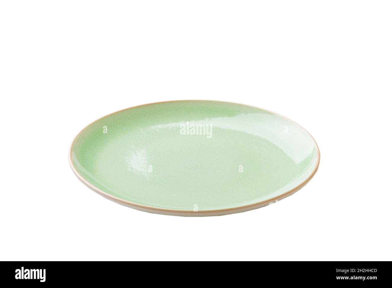 Green ceramic round plate isolated over white background. perspective ...