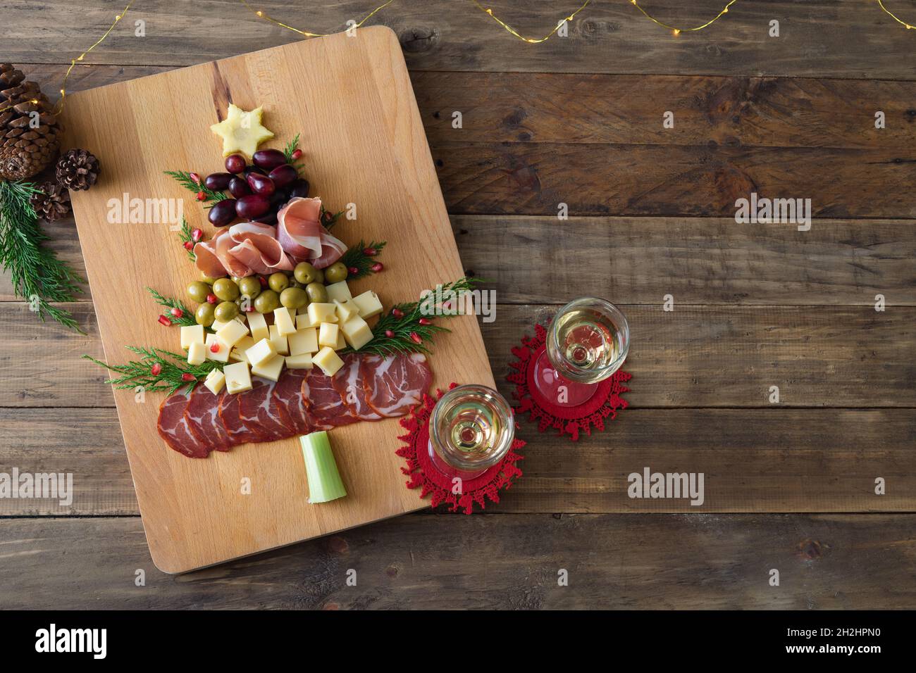 Christmas tree-shaped cheese and charcuterie appetizer board with ...
