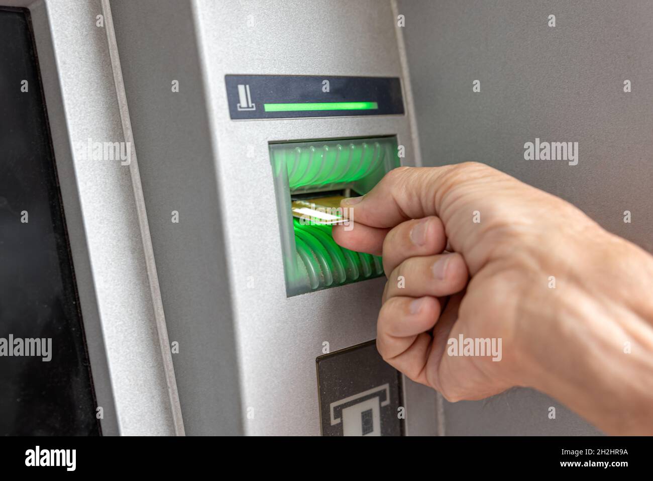 Male hand using credit card to withdraw money from ATM bank machine ...