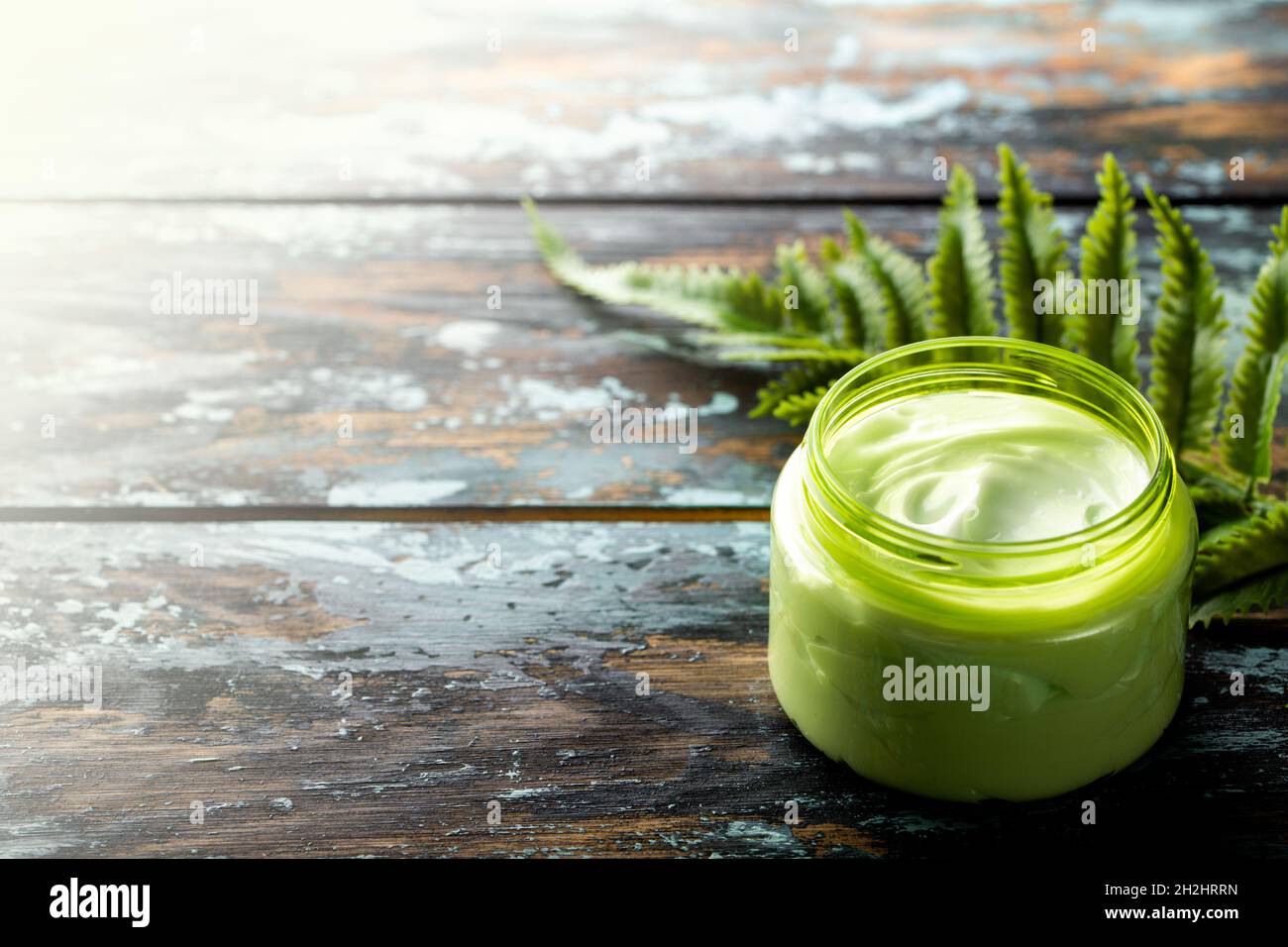 Cosmetic cream in container with green leaf Stock Photo - Alamy