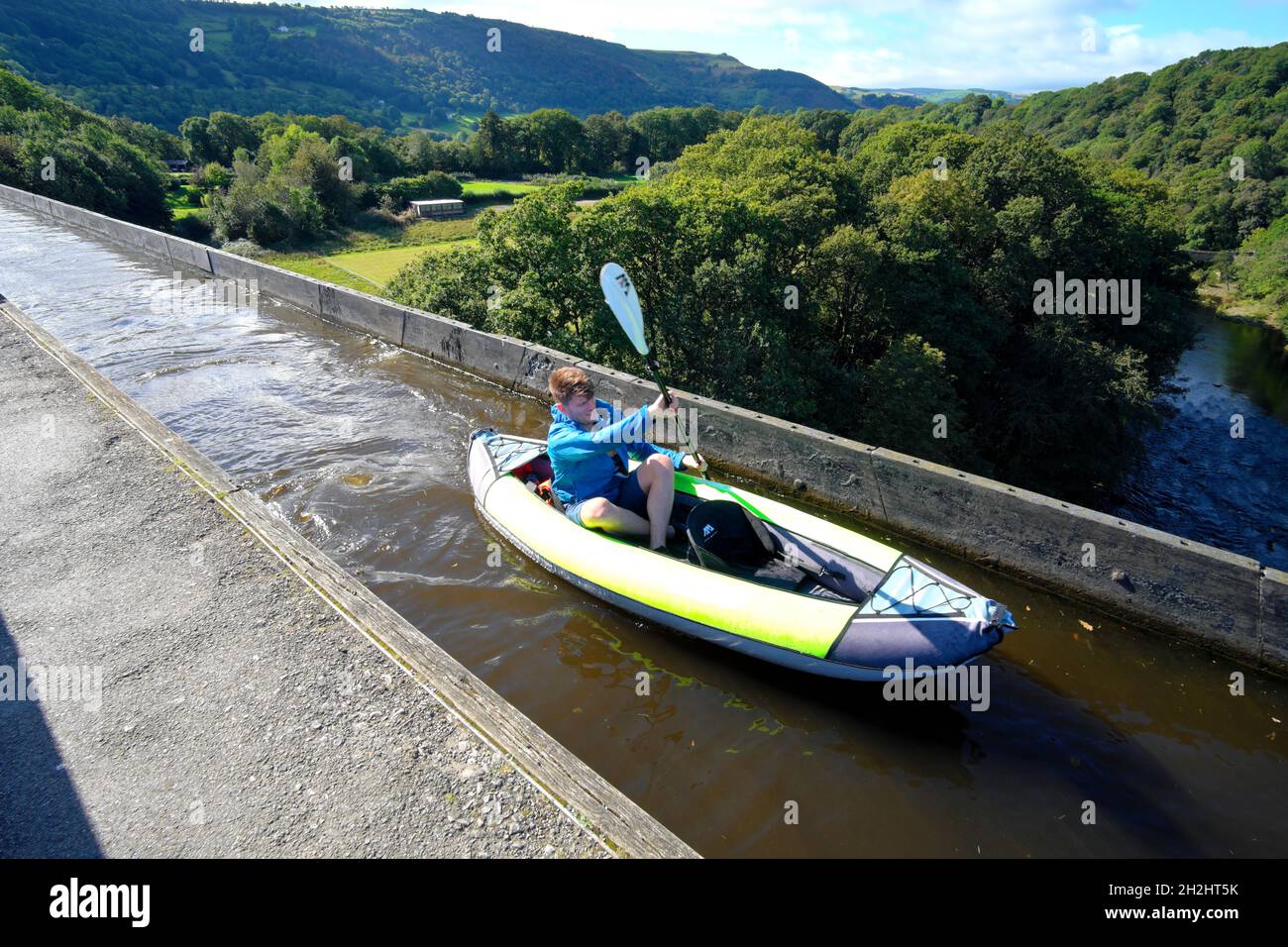 Young man in an inflatable canoe rows along the Pontcysyllte Aqueduct ...