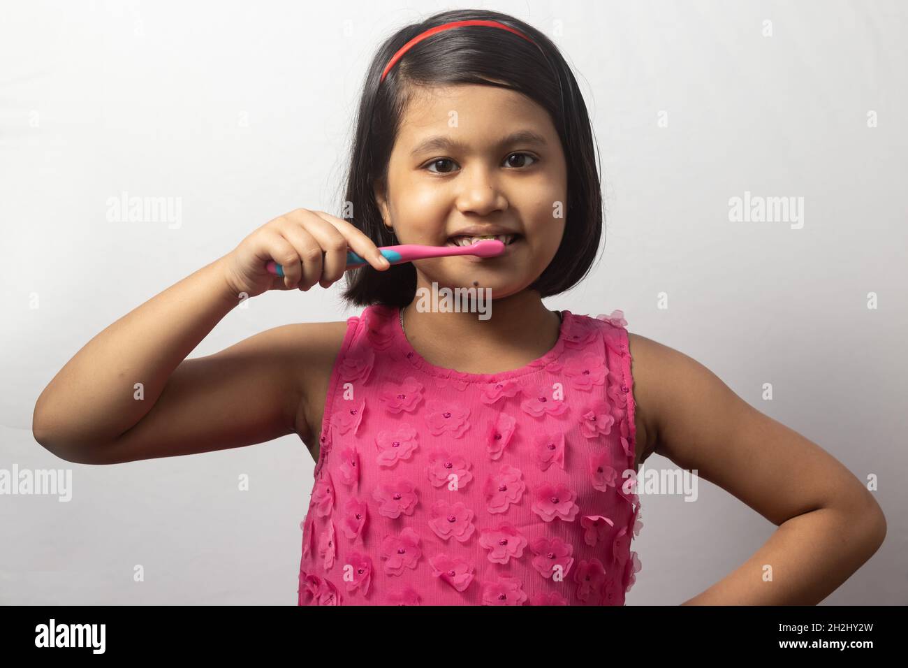 Portrait of an Indian girl child brushing teeth with toothbrush on ...