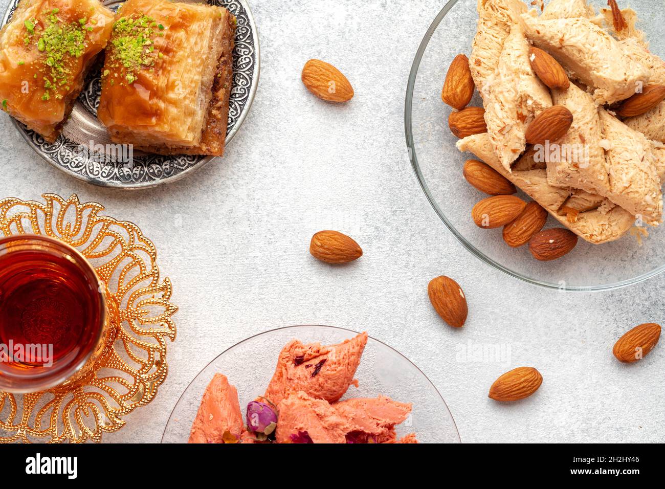 Assortment of Turkish delights with glass of tea on gray background ...
