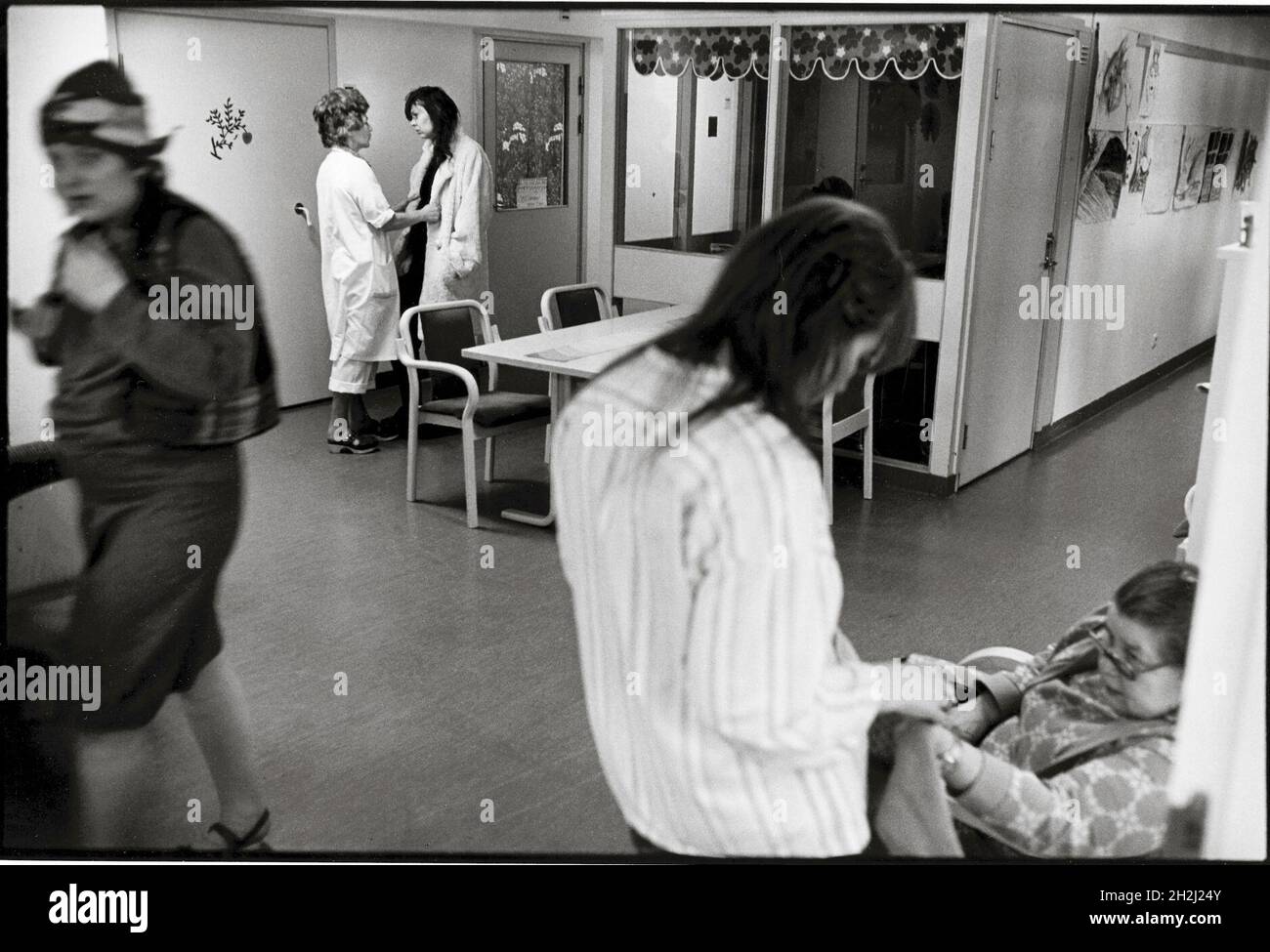 Female nurse talking to female mental patient in day room at ...
