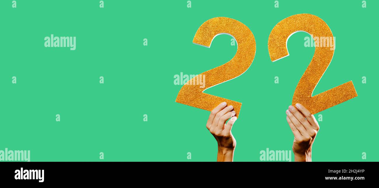 a young man holds two golden three-dimensional numbers forming the ...