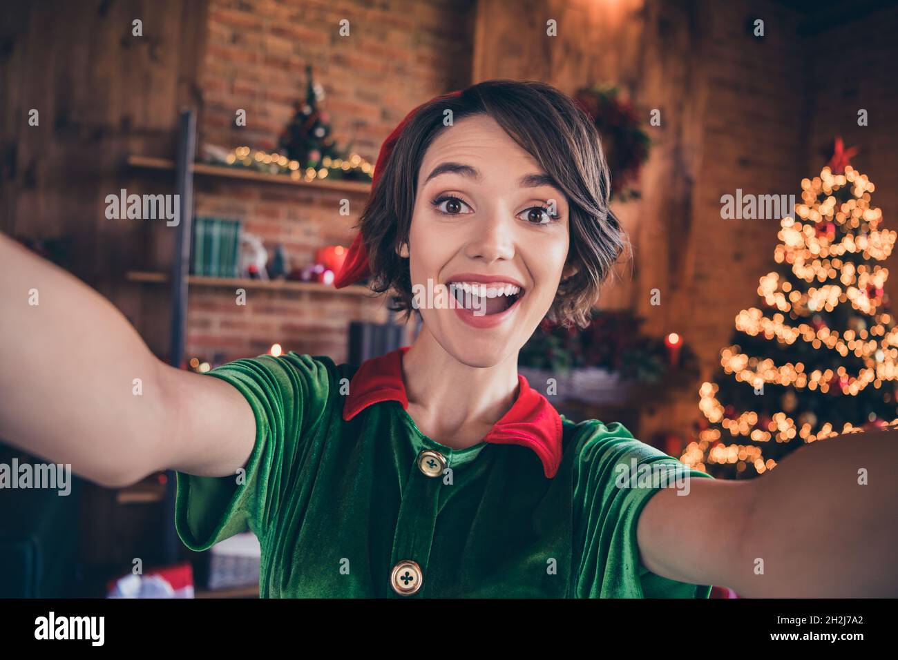 Photo of young cheerful shocked woman elf hold hands camera make selfie ...