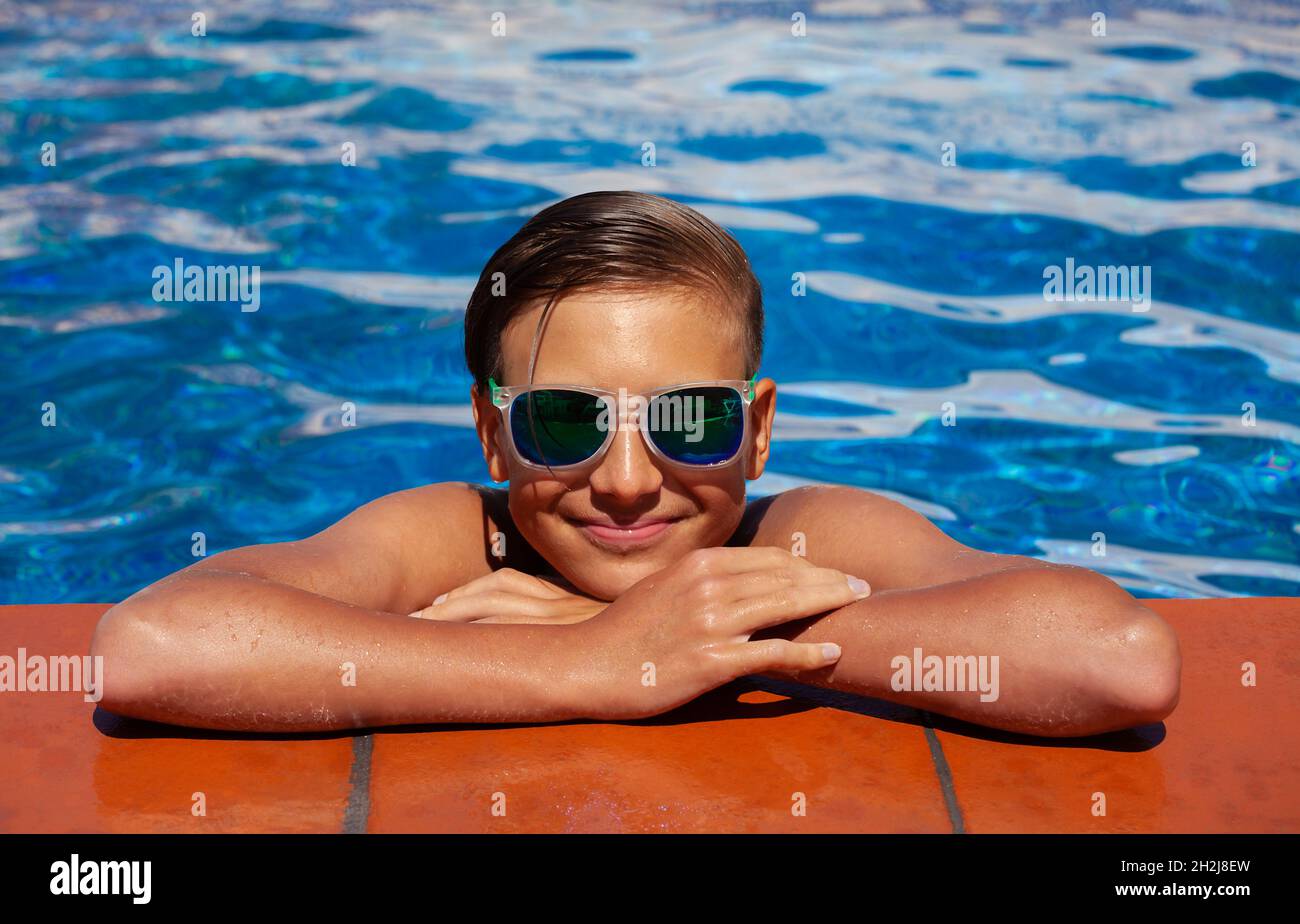 Portrait of a smiling boy in sunglasses in the swimming pool. Summer ...