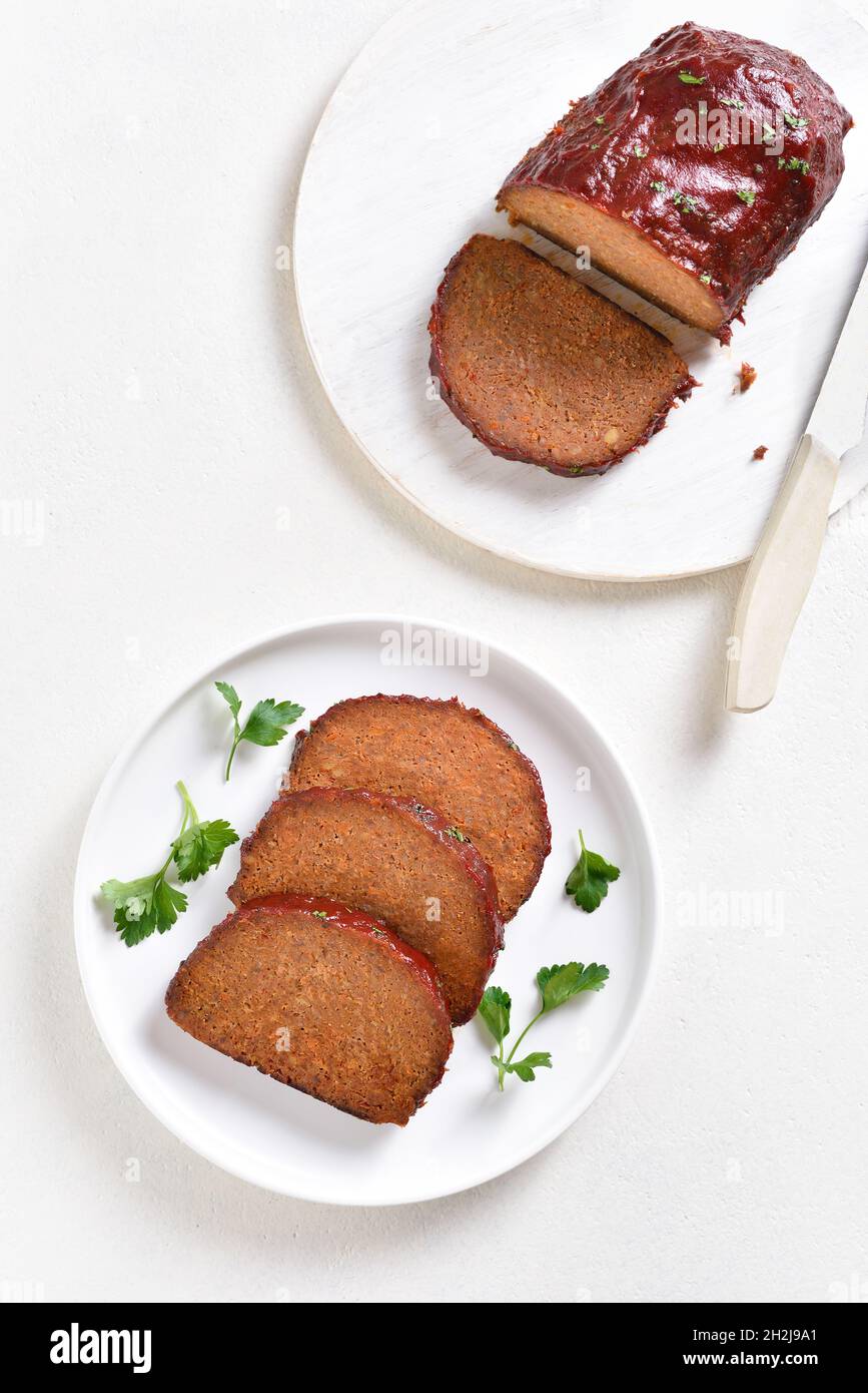 Sliced meatloaf over white stone background. Top view, flat lay, close ...