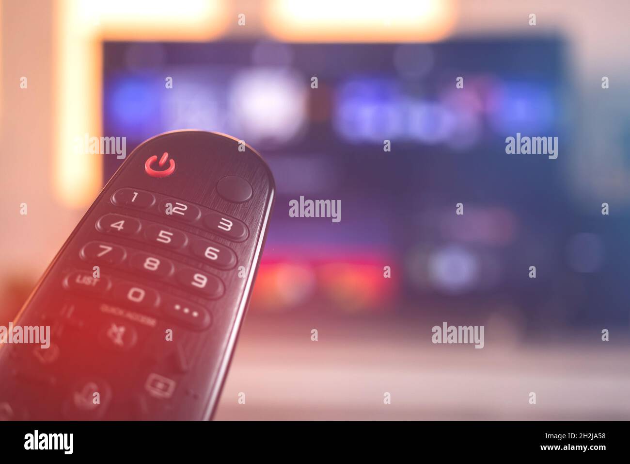 Smart TV remote control. Hand with TV remote control with a television ...