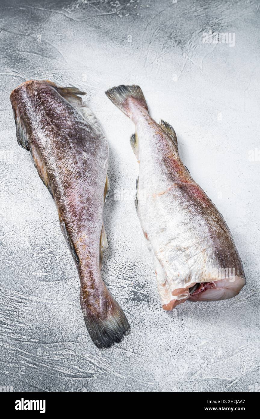 Raw cod whole fish on kitchen table. White background. Top view Stock ...