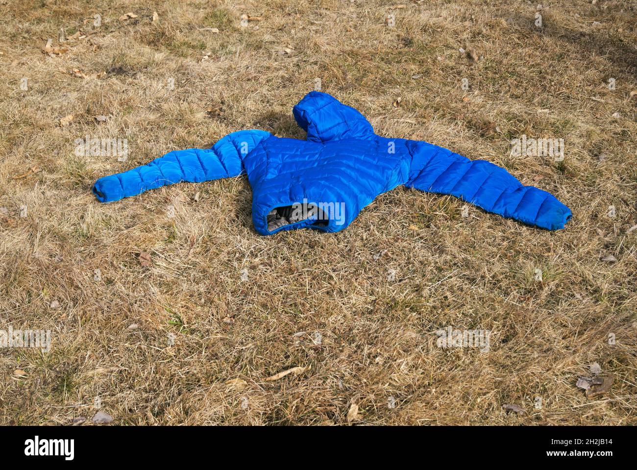 blue padded jacket lying on the ground Stock Photo - Alamy