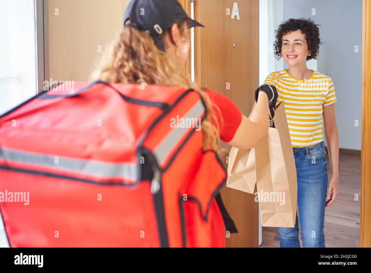 A delivery woman delivers a food order to a customer Stock Photo - Alamy
