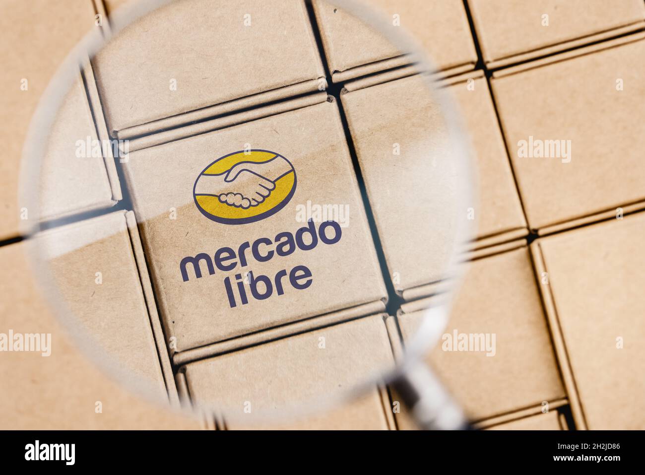 Modified photo of Mercado Libre logo on a box under a magnifying glass ...