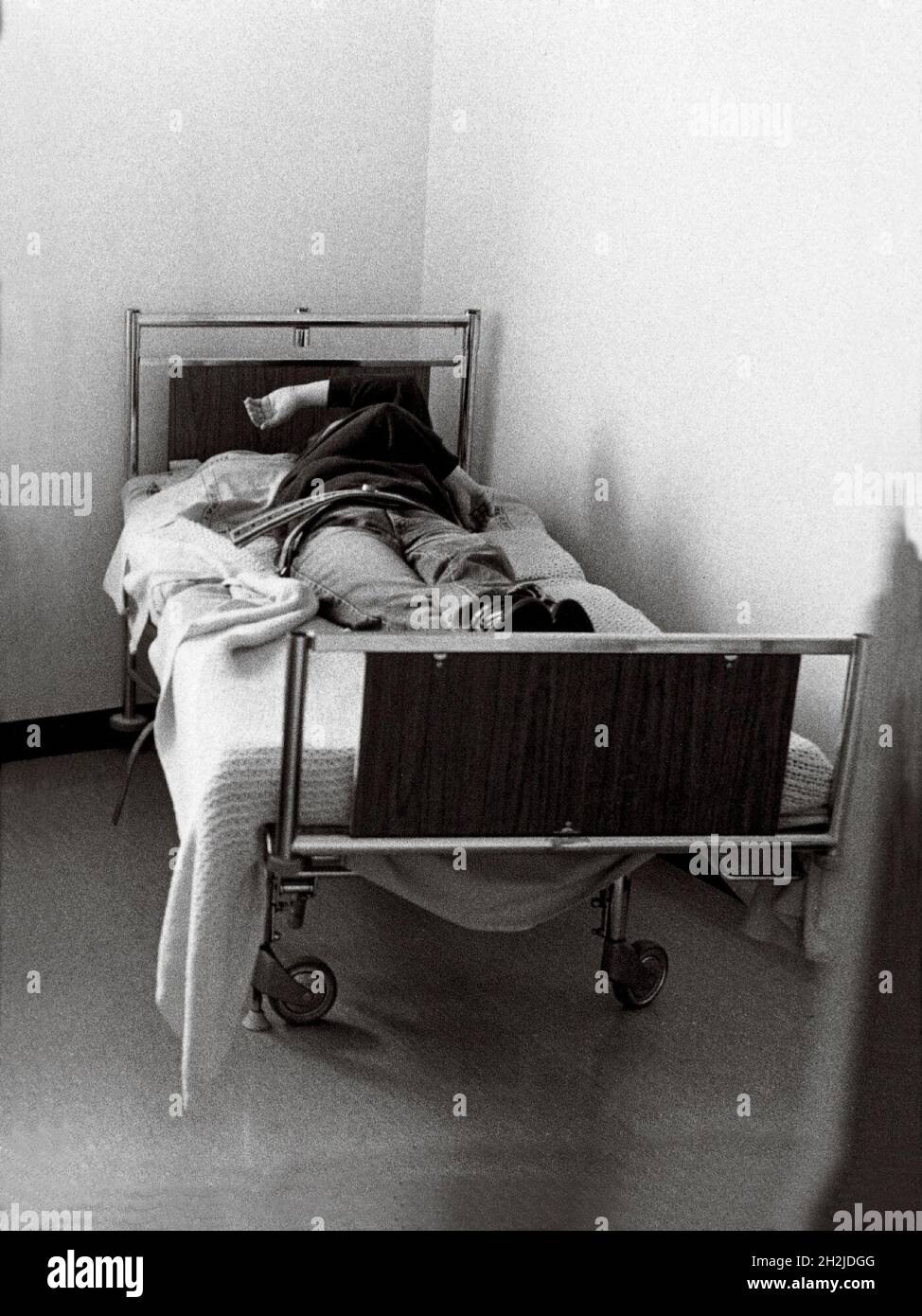 Belted mental patient covering his face in hospital bed Stock Photo - Alamy